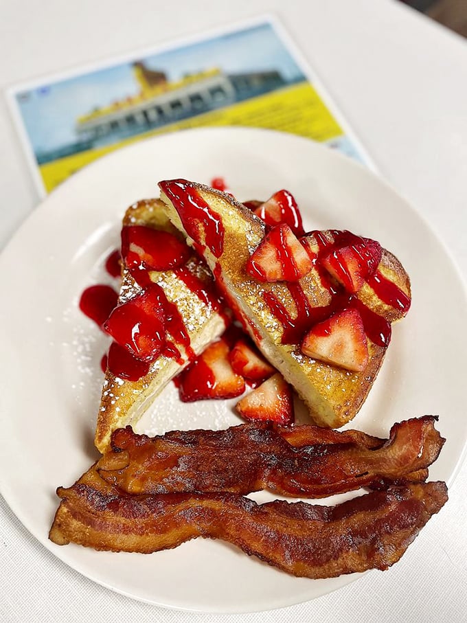French toast topped with fresh strawberries and a side of perfectly crisped bacon—proof that breakfast is indeed the most important art form of the day.