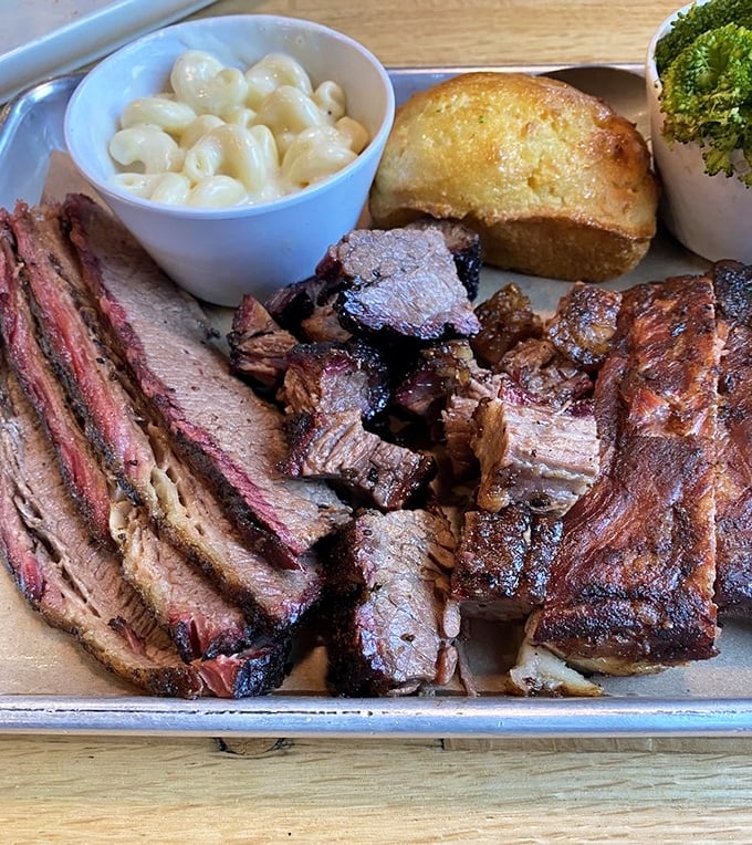 Not so much a meal as a carnivorous carnival—brisket, ribs, and pulled pork sharing a metal tray like the Mount Rushmore of smoked proteins.
