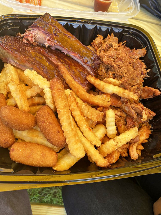 The holy trinity of barbecue – ribs, pulled pork, and those golden fries. This tray should come with a warning: "May induce immediate happiness."