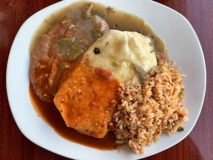The perfect marriage of textures: pillowy beans wrapped in a tender tortilla, bathed in green chile sauce, with Spanish rice playing the supportive best friend role.