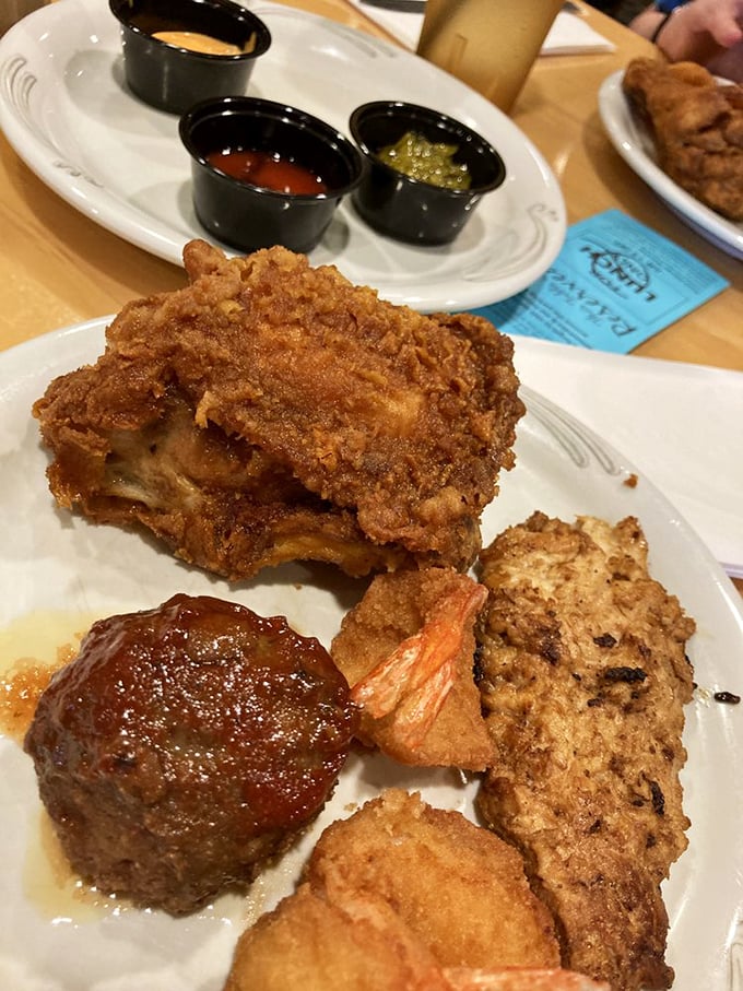 A plate that tells a story of perfect balance—crispy chicken, savory meatball, and vegetables playing supporting roles in this edible ensemble cast.