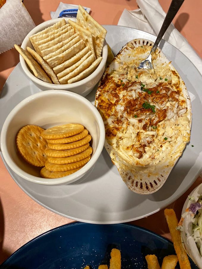 Hot crab dip served in a bubbling oval dish with crackers standing at attention—like a warm, cheesy welcome committee from the Chesapeake Bay.