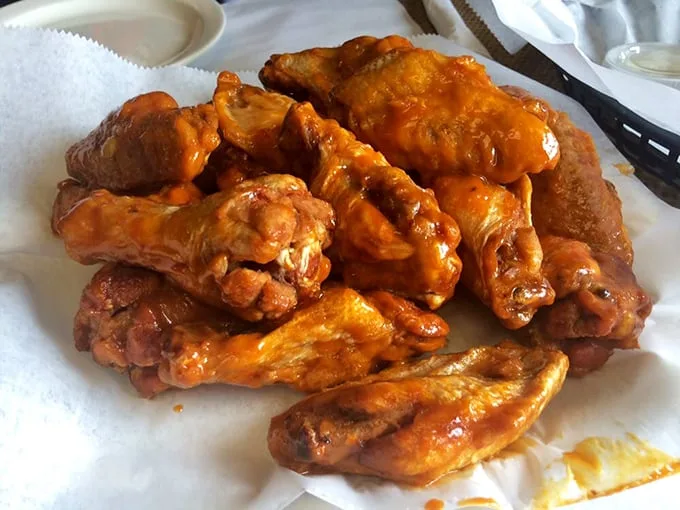 Buffalo wings glowing with that signature orange sauce – the kind that demands extra napkins and leaves your fingers deliciously stained with no regrets.