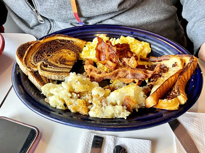 Breakfast architecture at its finest—crispy bacon, fluffy eggs, and home fries that make you question all other potatoes you've known.