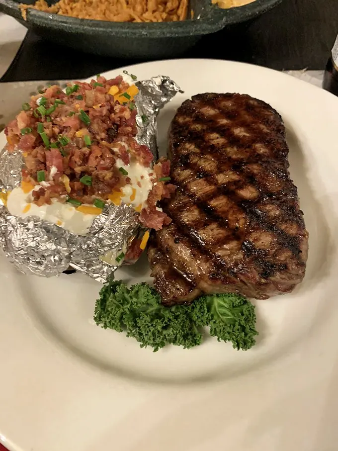 A perfectly charred NY Strip beside a potato that's having an identity crisis as a dessert. That's not just a side; it's a supporting actor deserving its own award.