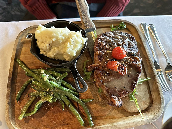 This ribeye doesn't just sit on the plate – it commands attention. The kind of steak that makes conversation stop mid-sentence.