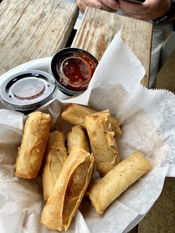 Spring rolls that crunch louder than your flip-flops on the deck, paired with dipping sauces worth the drive alone.
