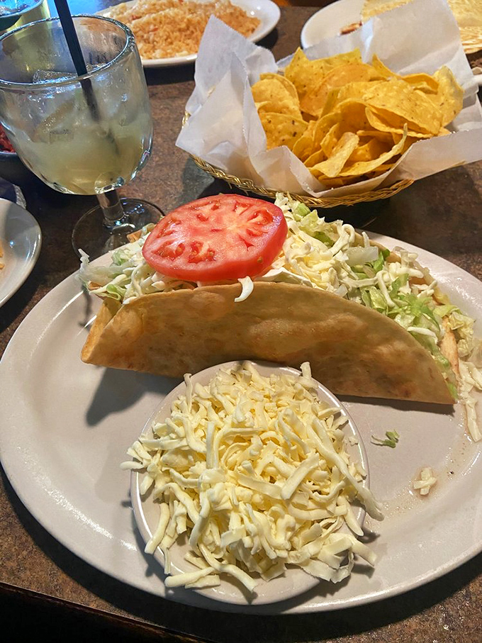 The taco salad arrives like edible architecture—crispy shell, fresh vegetables, and a mountain of cheese that makes you wonder if you should eat it or frame it.