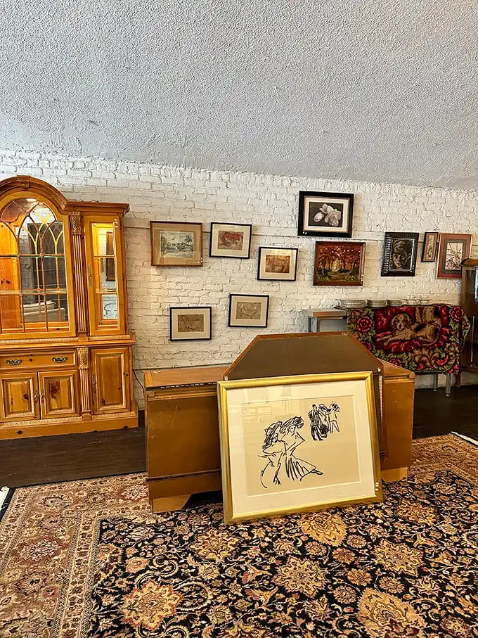 The art wall showcases framed treasures against exposed brick, proving one person's discard is another's perfect living room statement piece.
