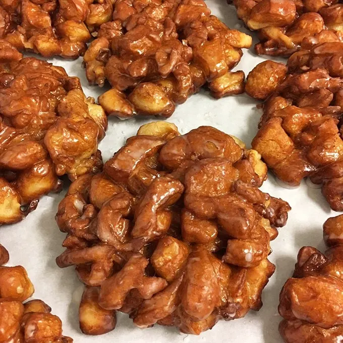 These apple fritters aren't just fried dough—they're architectural marvels of caramelized edges and tender centers. Each craggy surface captures glaze like nature's perfect design.