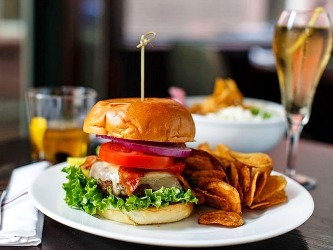 The burger arrives like a culinary superhero—cape optional, sidekick of house-made chips mandatory, and a flavor profile that deserves its own theme music.