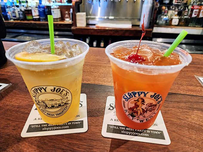 Two plastic cups of liquid sunshine—one golden, one sunset orange—ready to transform strangers into friends and inhibitions into distant memories.