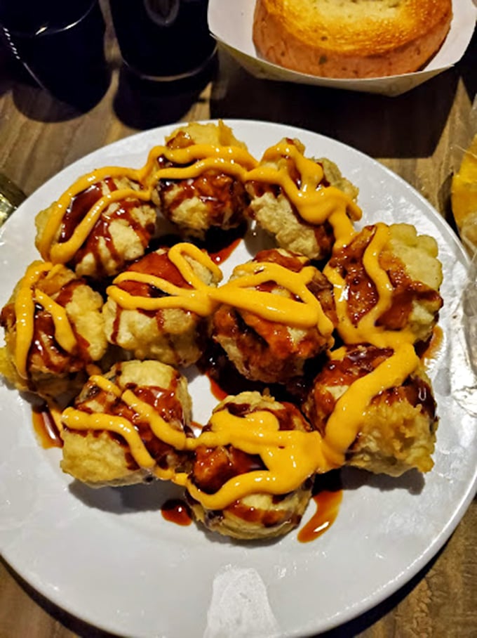 What looks like crispy golden clouds are actually Bang Bang shrimp—crunchy, saucy little flavor bombs that disappear faster than your resolution to share.