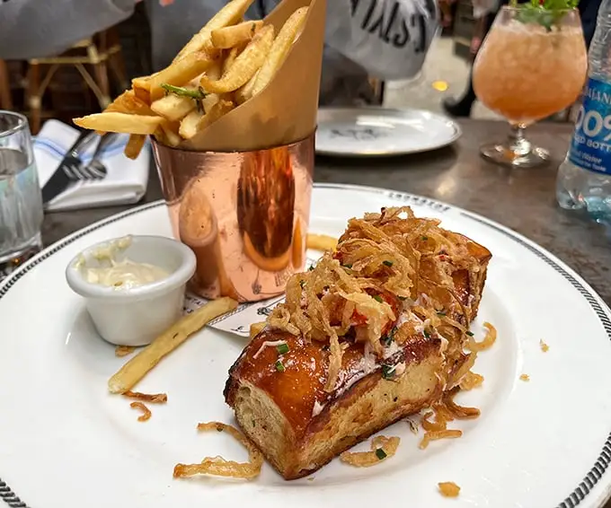 The lobster roll arrives like a celebrity – perfectly dressed, ready for its close-up, and surrounded by a golden entourage of fries.