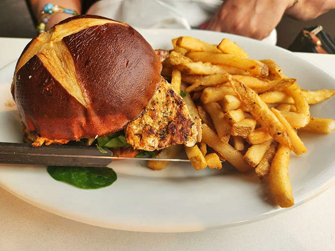 A sandwich so glorious it deserves its own anthem. That pretzel bun and golden fries combo could make a food photographer weep with joy.