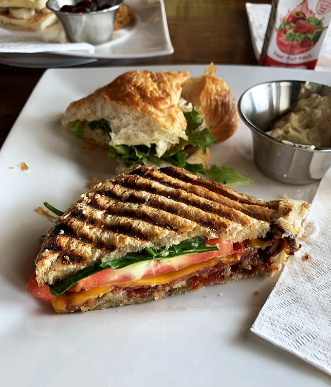 The grilled sandwich isn't just lunch—it's architecture. Layers of cheese, tomato, and greens create the Taj Mahal of midday meals, complete with soup sidekick.