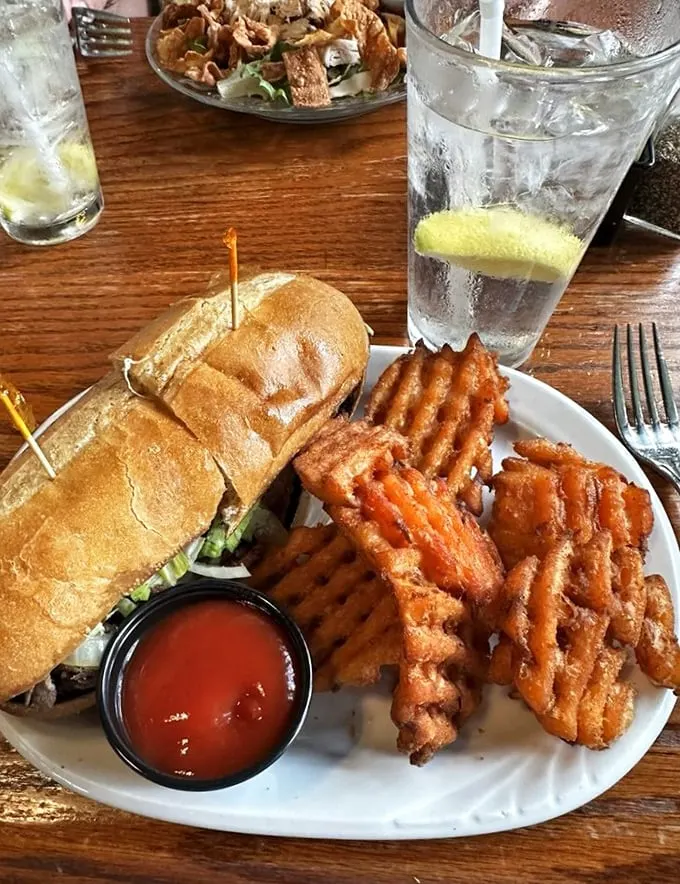Sandwich architecture at its finest! This hearty creation comes with waffle fries so perfectly crisp they deserve their own fan club.