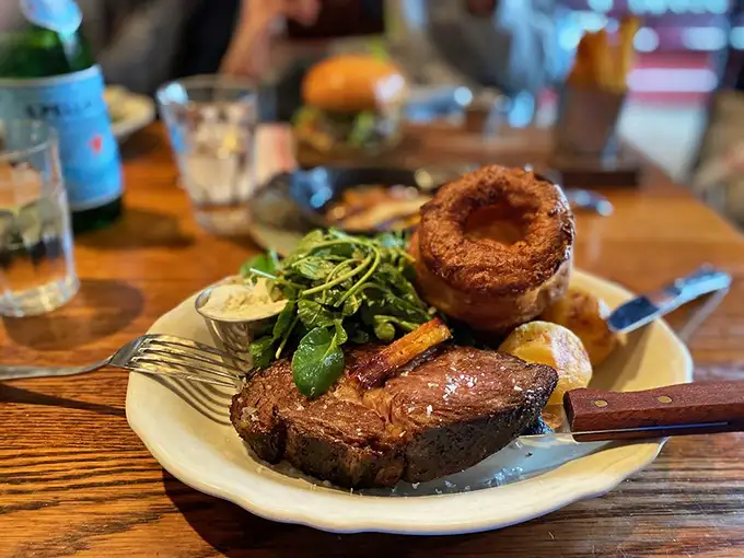 Sunday roast done right—a perfectly pink slab of beef, Yorkshire pudding standing tall like a proud British monument, and vegetables that didn't suffer the boiling fate of old English cuisine.