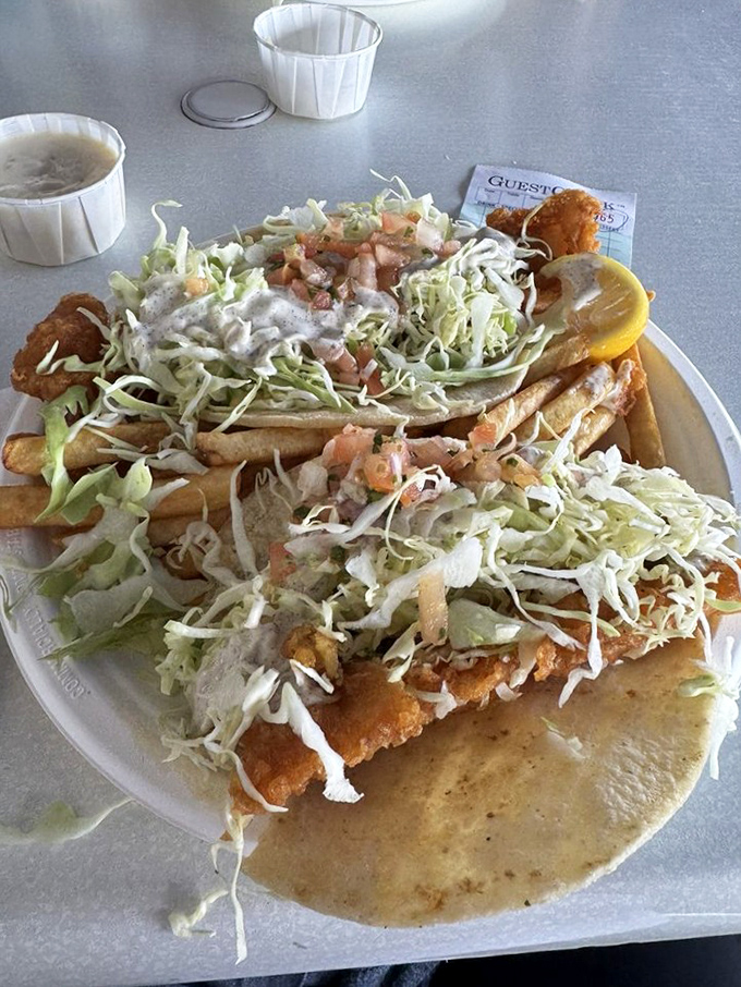 Fish tacos piled high with fresh slaw—proof that sometimes the best architectural achievements involve tortillas rather than concrete.