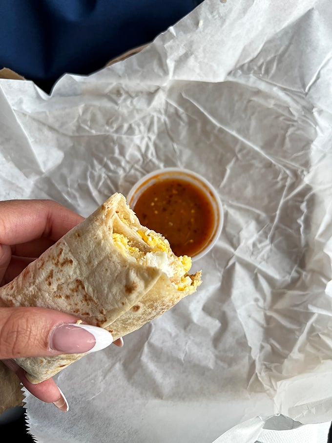 Behold, the breakfast burrito in its checkered paper cradle—like finding the Hope Diamond in a gas station, but infinitely more satisfying.