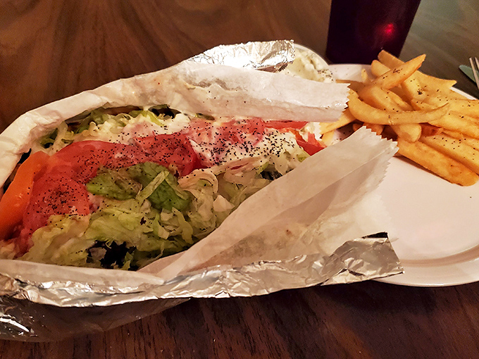 This open-faced gyro isn't just a meal, it's an architectural marvel of meat, veggies, and sauce that would make Zorba himself dance with joy.