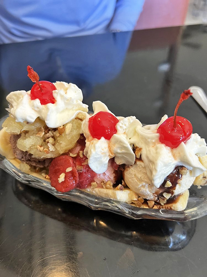 Ice cream architecture at its finest! This banana split is the skyscraper of desserts—layers of flavor crowned with cherries that demand to be photographed before devoured.