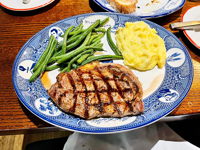 A perfectly grilled ribeye shares the spotlight with vibrant green beans and creamy mashed potatoes. Simple food done right is sometimes the most impressive culinary feat.