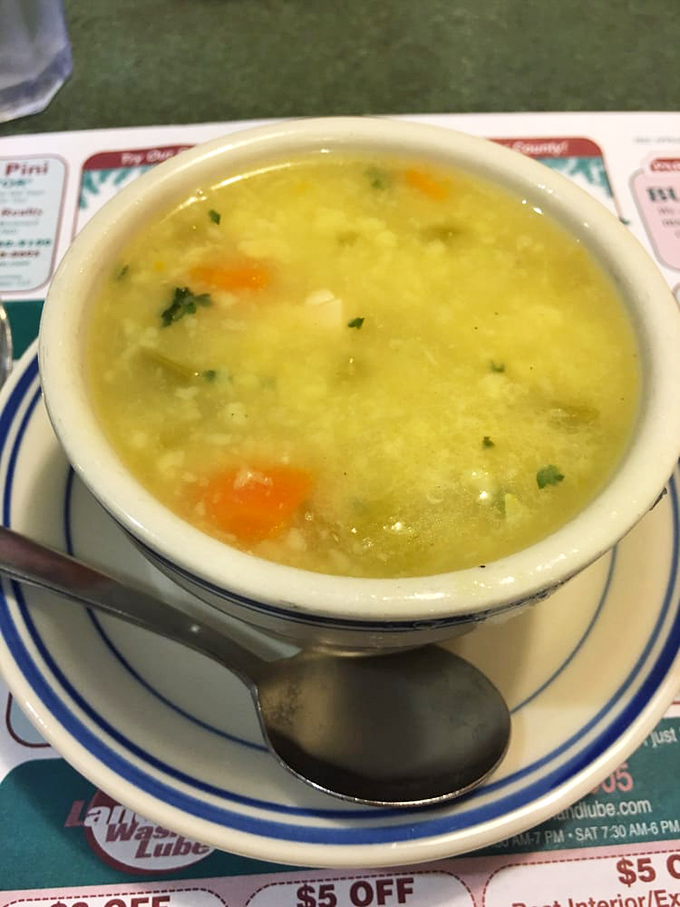 A bowl of chicken corn soup that looks like liquid comfort. The kind of soup your grandmother would approve of—clear broth, visible vegetables, and no pretentious garnishes.