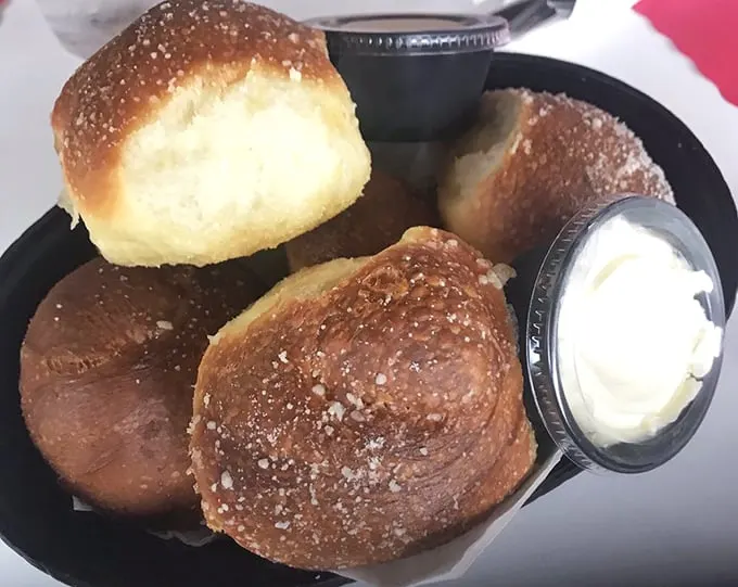These golden-brown dinner rolls aren't just bread – they're warm, pillowy vehicles for the butter that melts into their souls.