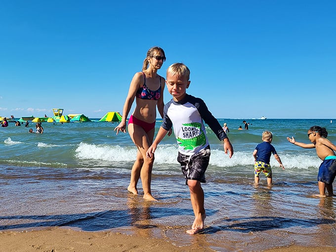 Shoreline joy in its purest form. Children test the waters while the WhoaZone beckons in the background—a perfect introduction to Lake Michigan's refreshing embrace.