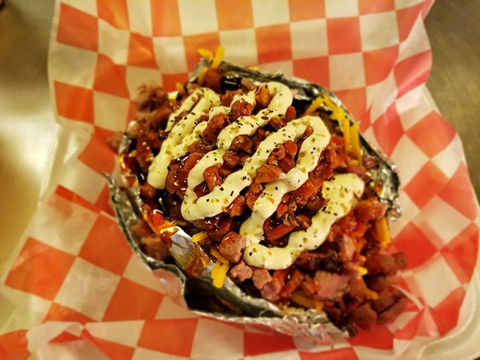 A foil-wrapped loaded potato cradles a mountain of toppings—proof that sometimes the best supporting actors deserve their own standing ovation.