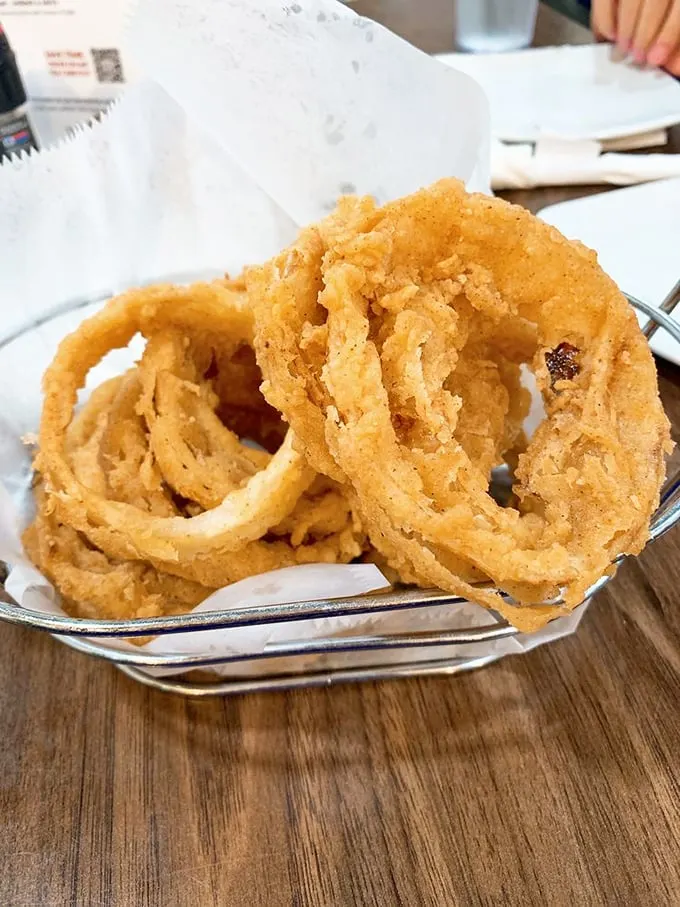 These onion rings aren't just fried—they're golden halos of crispy perfection that make you wonder why vegetables ever bother showing up any other way.