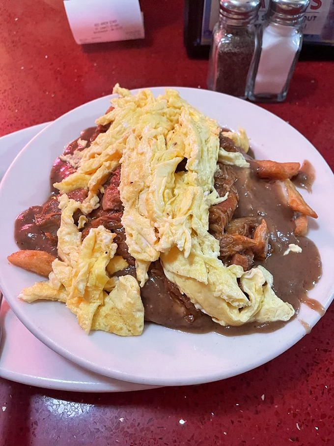 Behold the glorious mess that is diner poutine. Eggs, gravy, and fries having the kind of party your arteries fear but your soul craves.