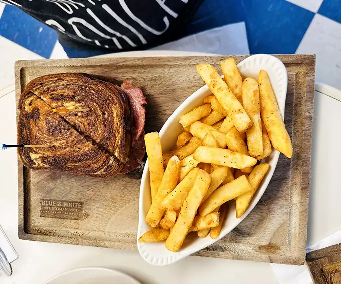 A sandwich and fries served on a wooden board – because sometimes the simple pleasures require no explanation. 