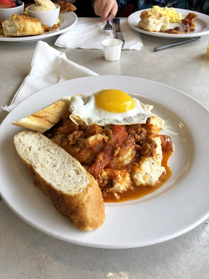 A breakfast sandwich that understands the assignment—golden egg, fresh greens, and a biscuit that deserves its own fan club. Those home fries are no slouch either.