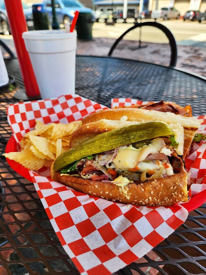 Outdoor dining with pickle spear sentinels—because some sandwiches deserve fresh air and admiring glances from passersby.