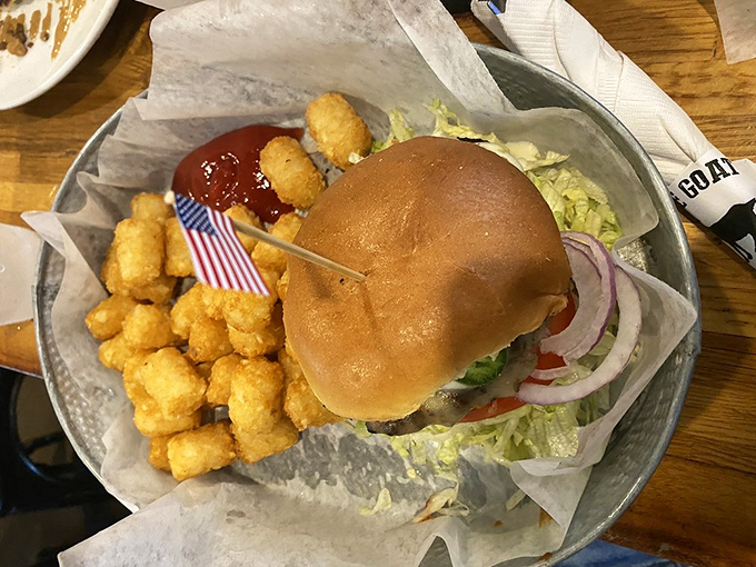 The Dragon arrives with its patriotic flag planted firmly in burger territory, surrounded by golden tot treasures. No fire-breathing necessary—the flavor brings the heat.