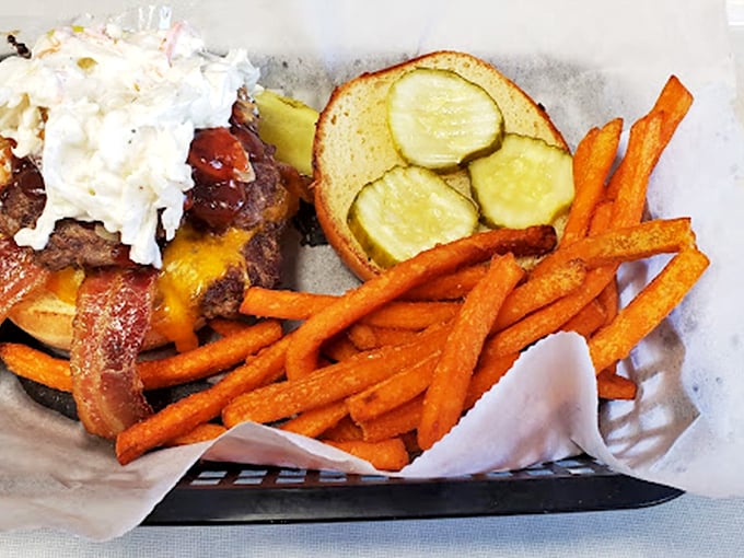 This isn't just a burger—it's an architectural marvel of beef, bacon, cheese, and fresh toppings, with sweet potato fries standing guard like delicious sentinels.