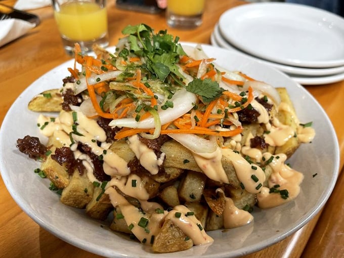 These aren't just breakfast potatoes—they're a canvas for culinary creativity, topped with a confetti of ingredients and a sauce that demands to be dragged through.