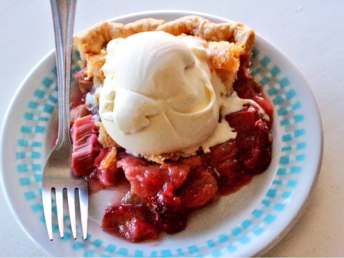 A slice of rhubarb pie topped with ice cream—proof that sometimes the best things in life require a fork and zero restraint.