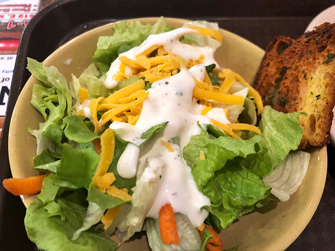 The token salad—a crisp, cheese-topped nod to nutrition that somehow makes you feel virtuous before demolishing three plates of fried catfish.