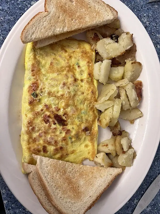 This Western omelet doesn't just whisper "good morning"—it belts it out with perfectly diced veggies, melted cheese, and home fries that demand attention.