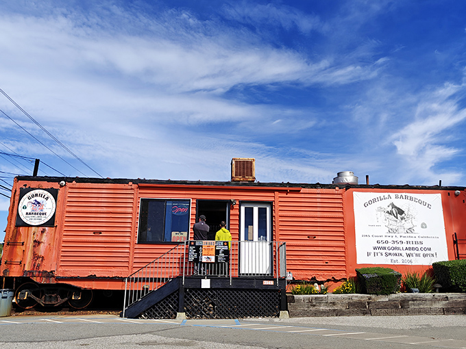 Gorilla Barbeque's bright orange railroad car stands as a beacon of hope for hungry travelers—a smoke signal of deliciousness ahead.