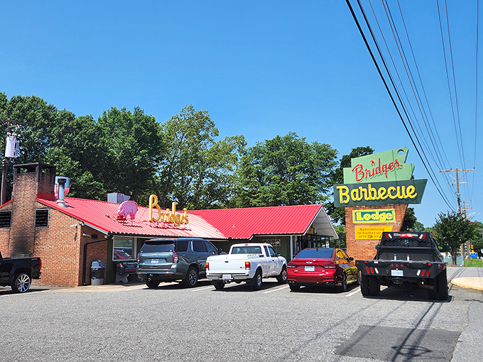 Bridges' neon sign glows like a barbecue lighthouse, guiding hungry travelers toward smoky salvation on a plate.