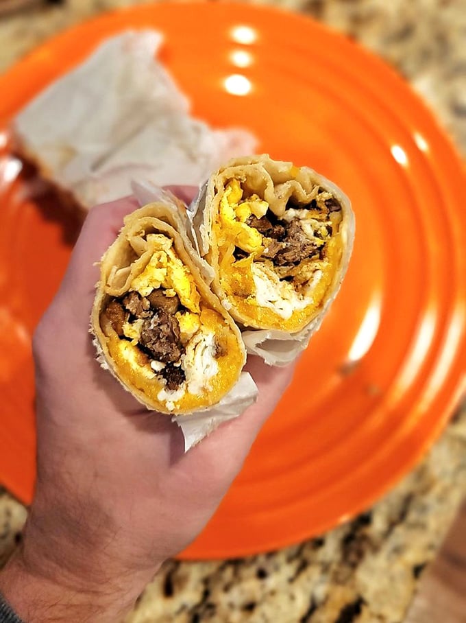 Cross-section perfection reveals the golden marriage of eggs and cheese embracing savory meat—a breakfast trilogy more compelling than any Hollywood franchise.