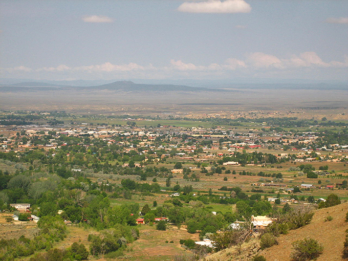 Taos from above reveals its perfect placement between mountain and mesa. The patchwork of greenery and adobe tells a story of human harmony with nature.