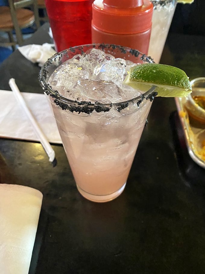 A salt-rimmed cocktail stands ready to cut through the richness of your burger adventure. Hydration is not just recommended—it's tactical.