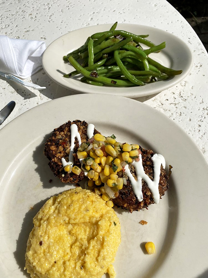 Black bean cakes with creamy grits and vibrant green beans—proof that Southern cuisine can dance gracefully into vegetarian territory without missing a beat.