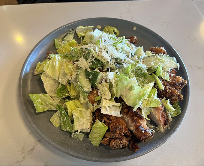 This Caesar salad isn't just wearing chicken—it's sporting it like a perfectly tailored suit of crispy, juicy deliciousness.