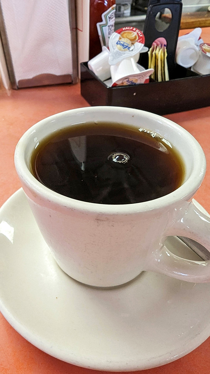 The unassuming diner mug holds the elixir of morning ambition – straightforward coffee that doesn't need a fancy Italian name to get the job done.